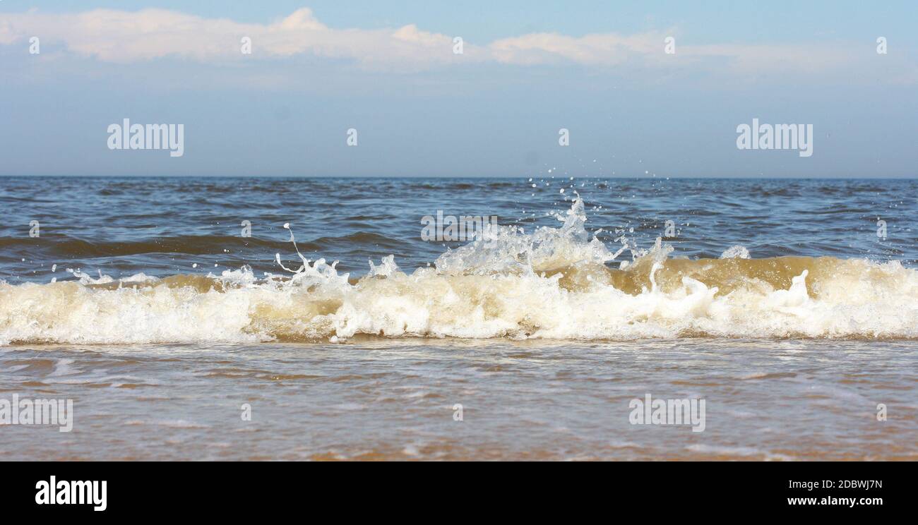 Waves with whitecaps flood the sandy beach Stock Photo - Alamy
