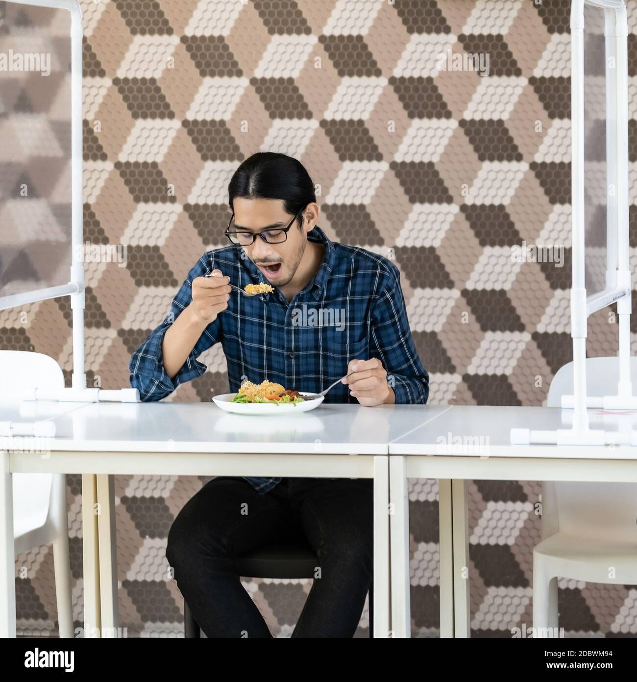 Portrait of asian young adult man eat fried rice food at new normal ...