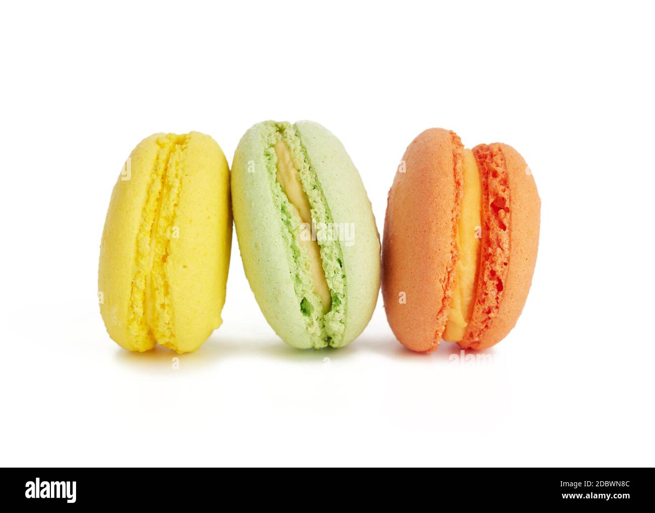 three multi-colored round baked macarons cakes isolated on a white ...