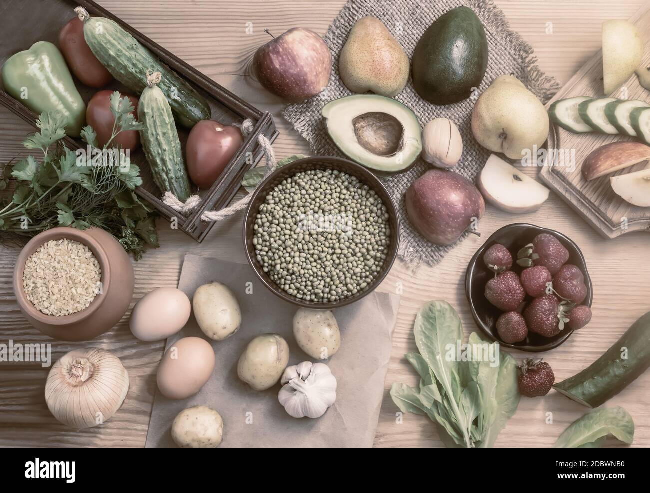 A variety of organic food items on the wooden table: fruits, vegetables ...
