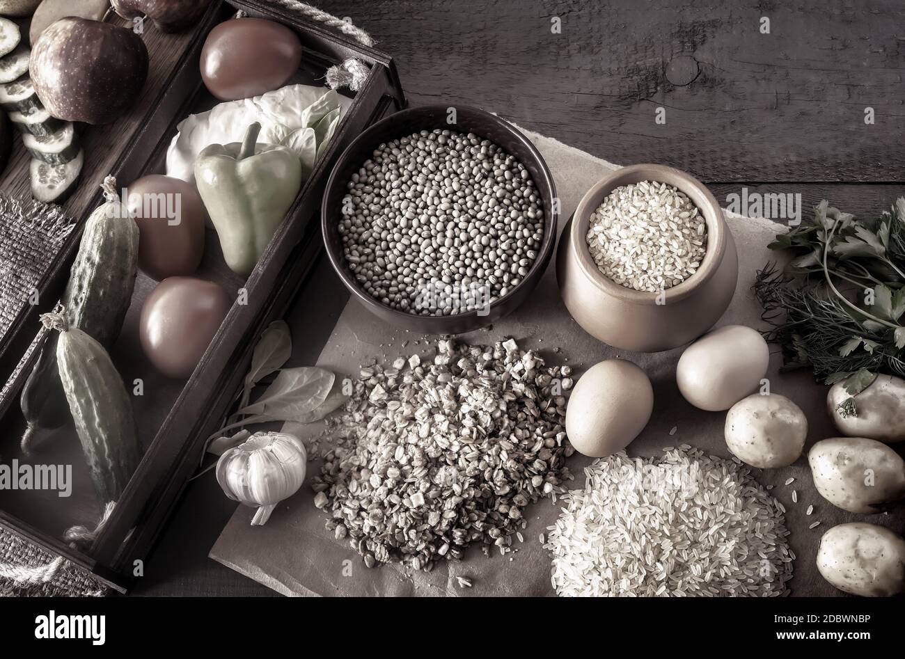 A variety of organic food items on the wooden table: fruits, vegetables ...
