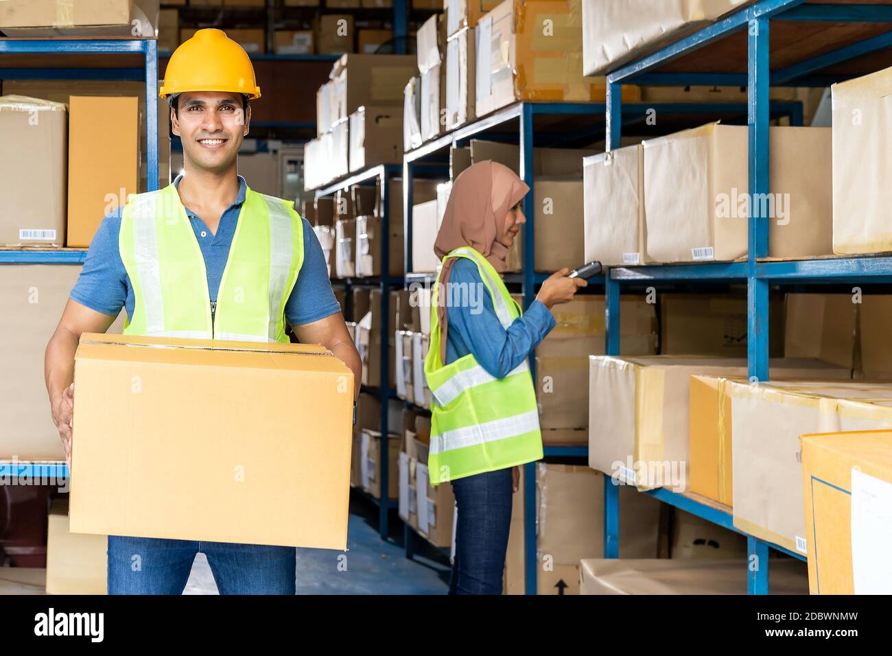 Portrait of Indian warehouse worker hold cardboard box packaging with ...