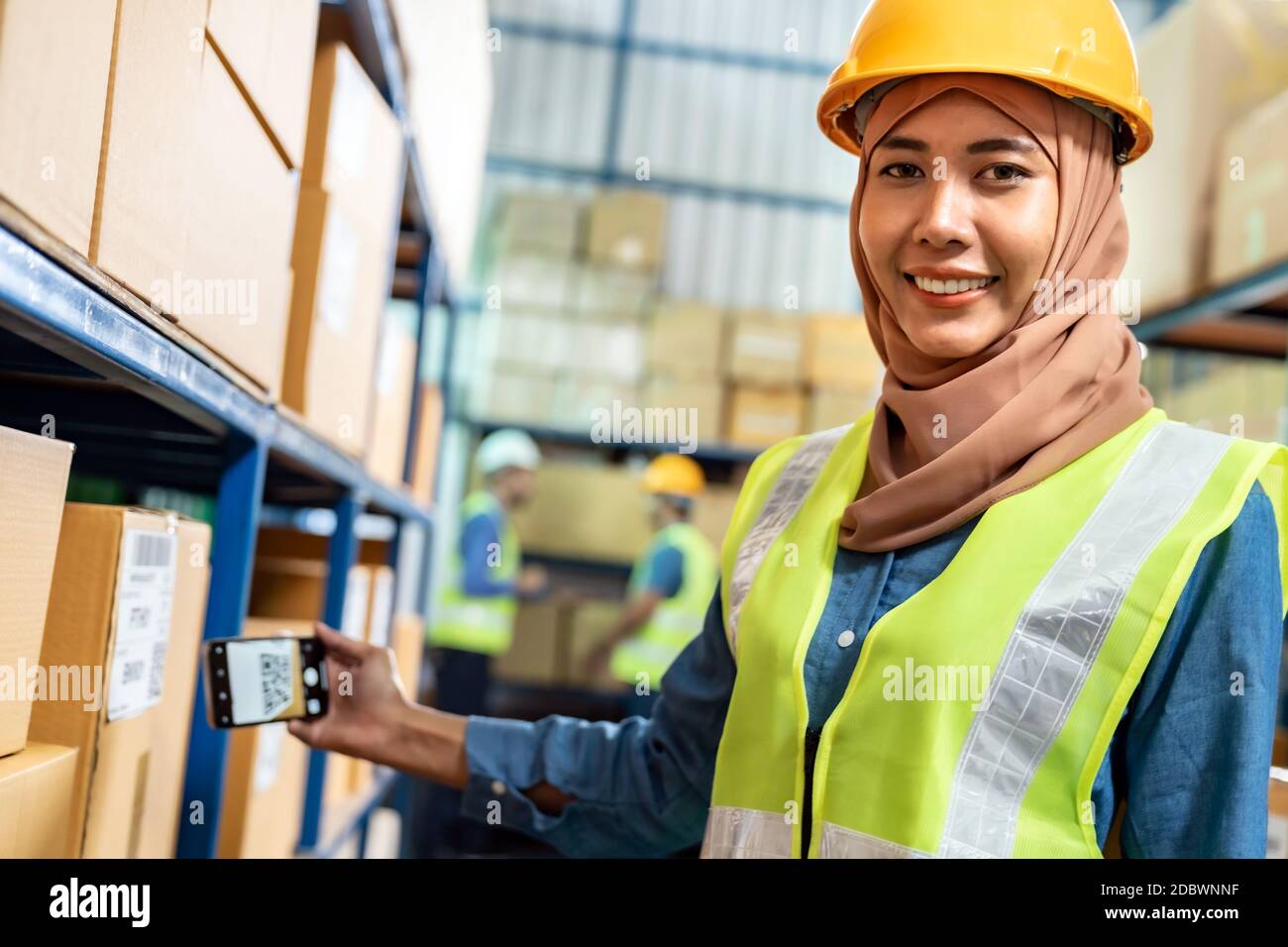 Portrait of Islam Muslim female warehouse worker use mobile phone scan ...