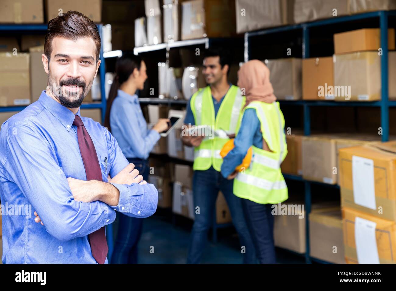 Portrait of White caucasian warehouse owner crossed arm with his worker ...