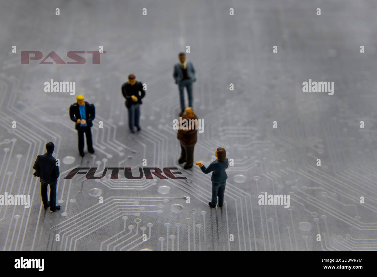 Miniature figurines posed as business people in a meeting over abstract ...