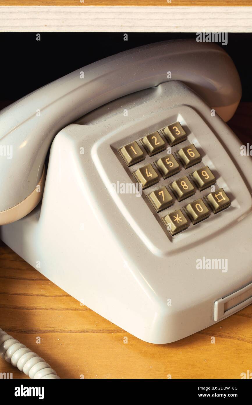 Old vintage phone with wire on wooden shelf, retro design close-up ...