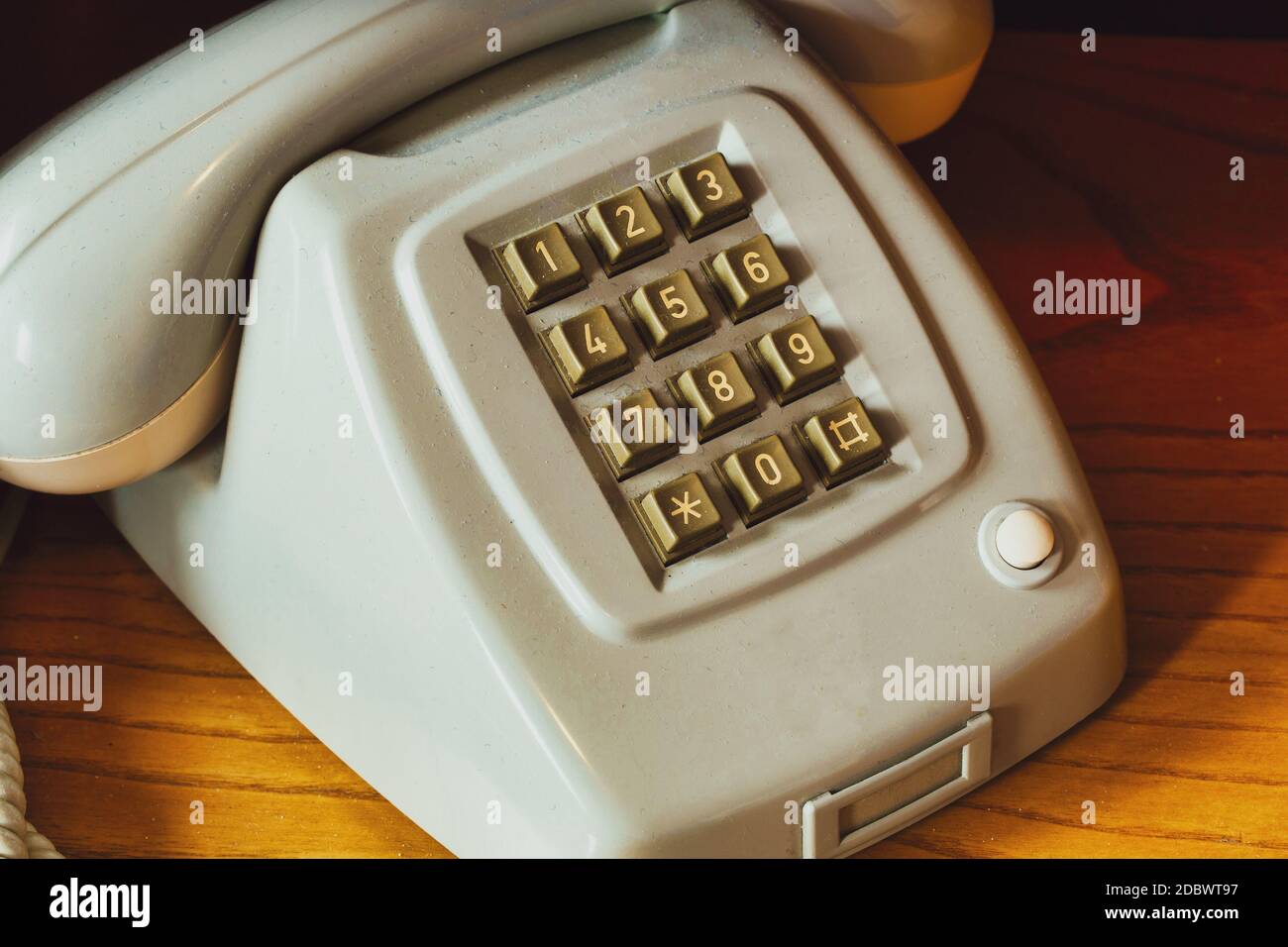 Old vintage phone with wire on wooden shelf, retro design close-up ...