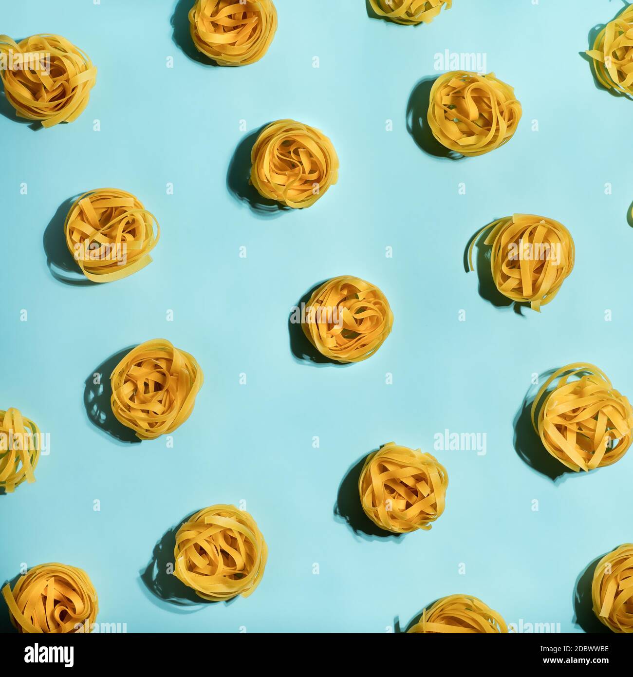 Pasta art. Tagliatelle on blue pastel background in hard light ...