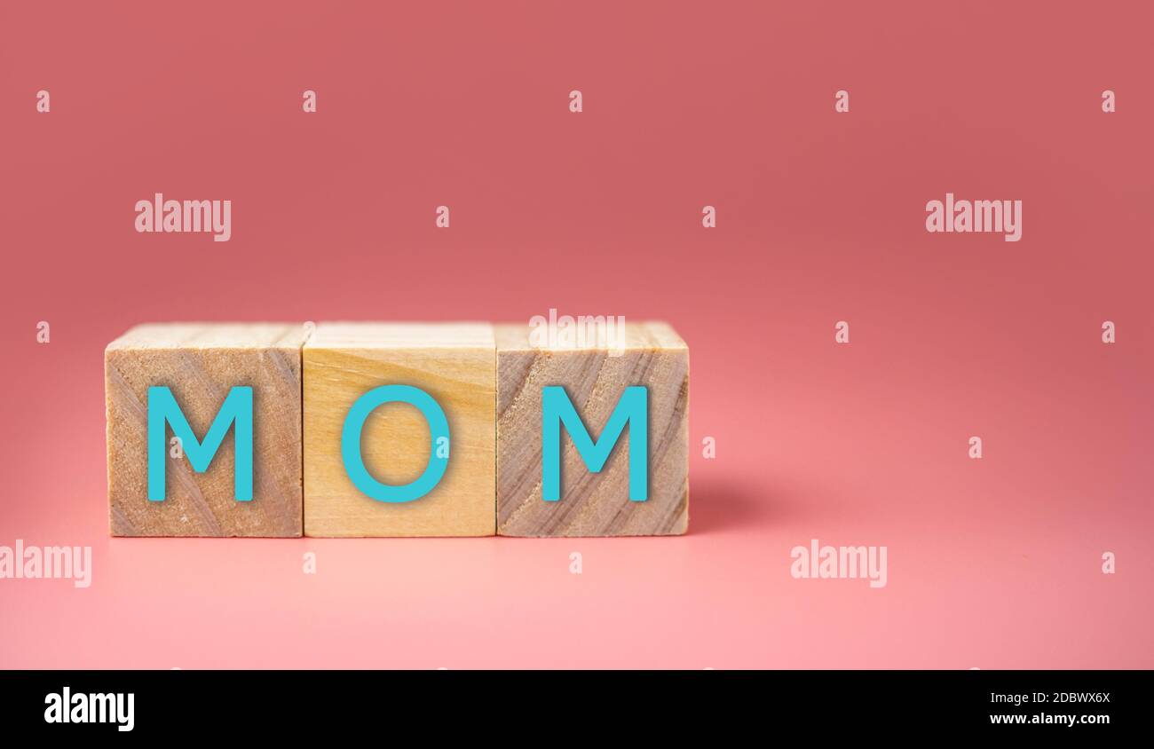 MOM Word Written In Wooden Cube on pink background. Mother's day ...