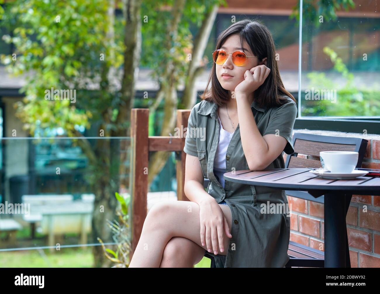Pretty woman sitting in a cafe terrace with coffee cup Stock Photo - Alamy
