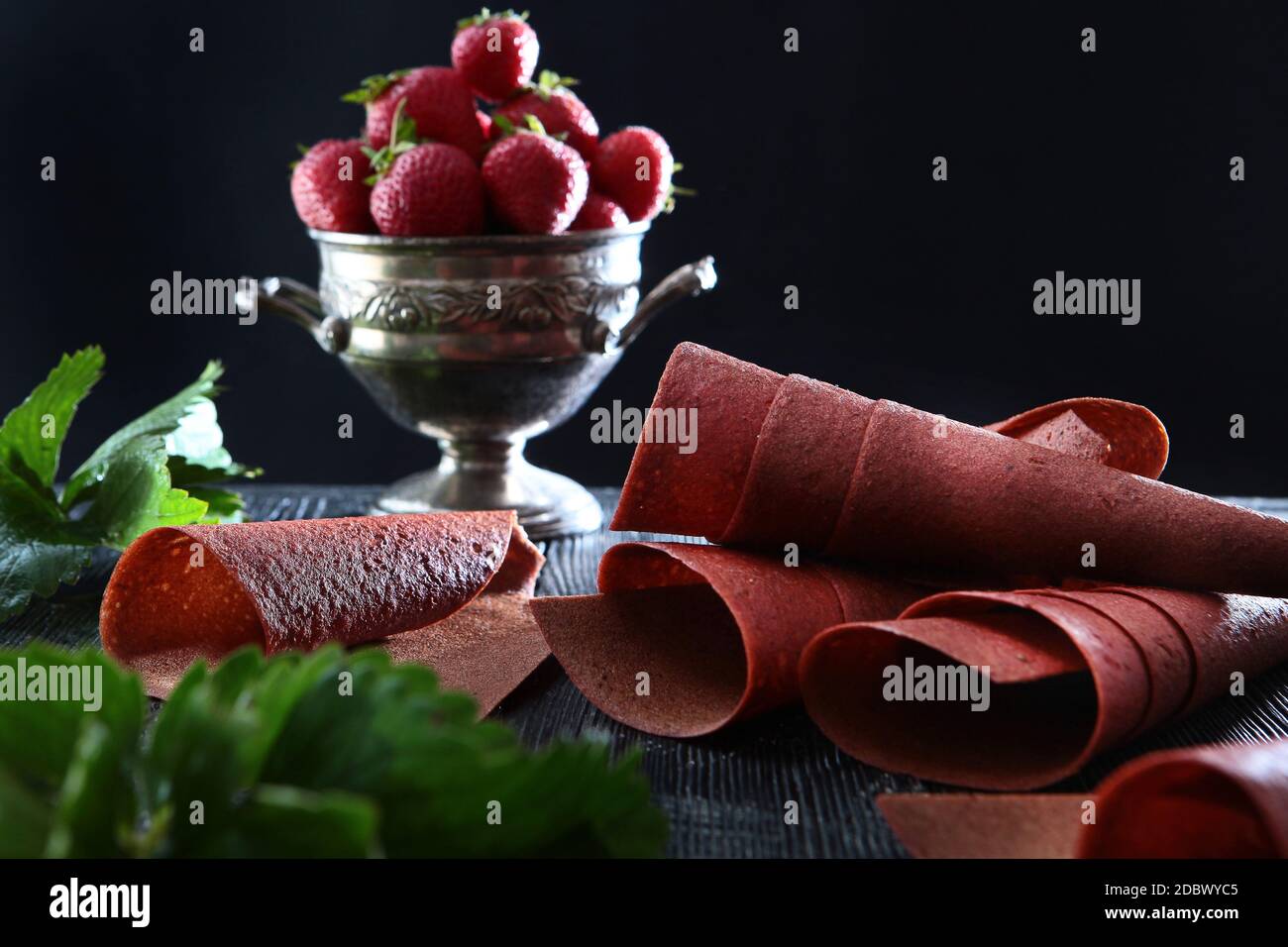 Fresh strawberries in an old metal vase. Natural pastille rolled into a ...