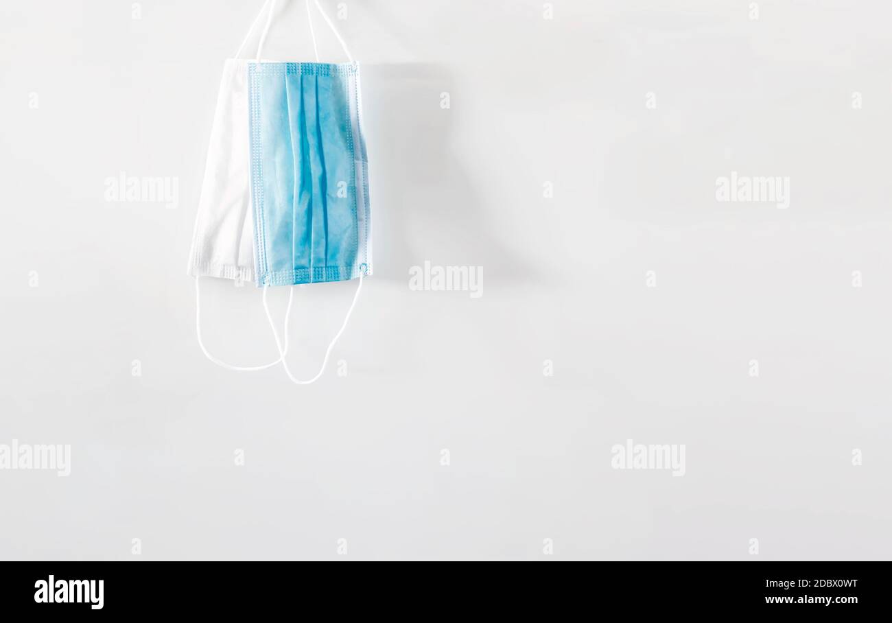 a pair of hanging surgical masks isolated on a white background ...
