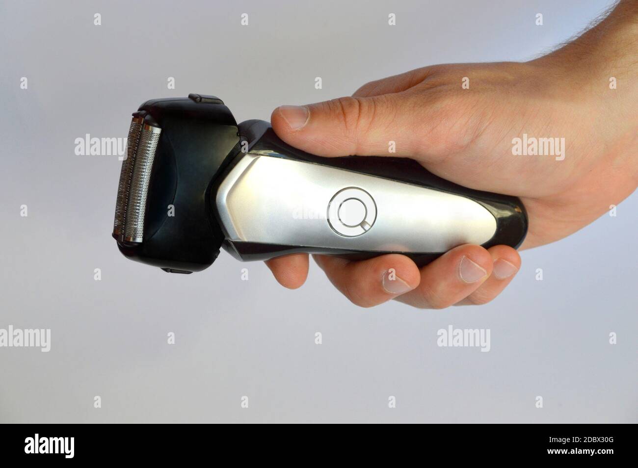 Male hand holding shaving machine on white background Stock Photo - Alamy