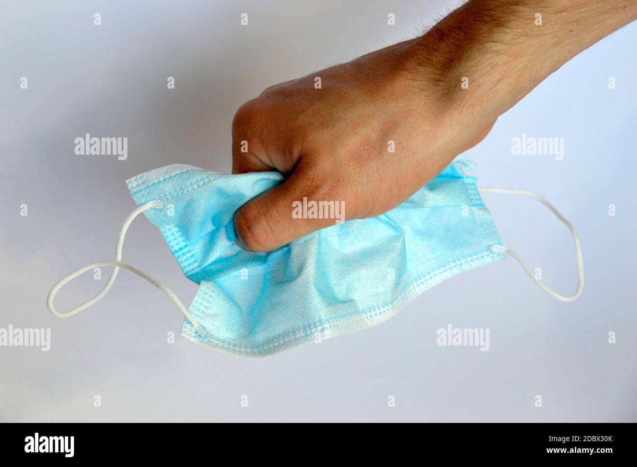 Male hand holding blue medical mask. concept taking off masks due to ...