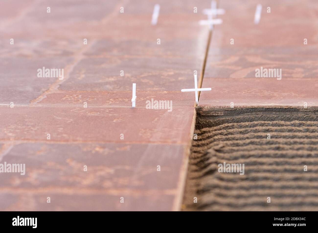 Laying ceramic tiles on a special cement mortar, mounting crosses are ...
