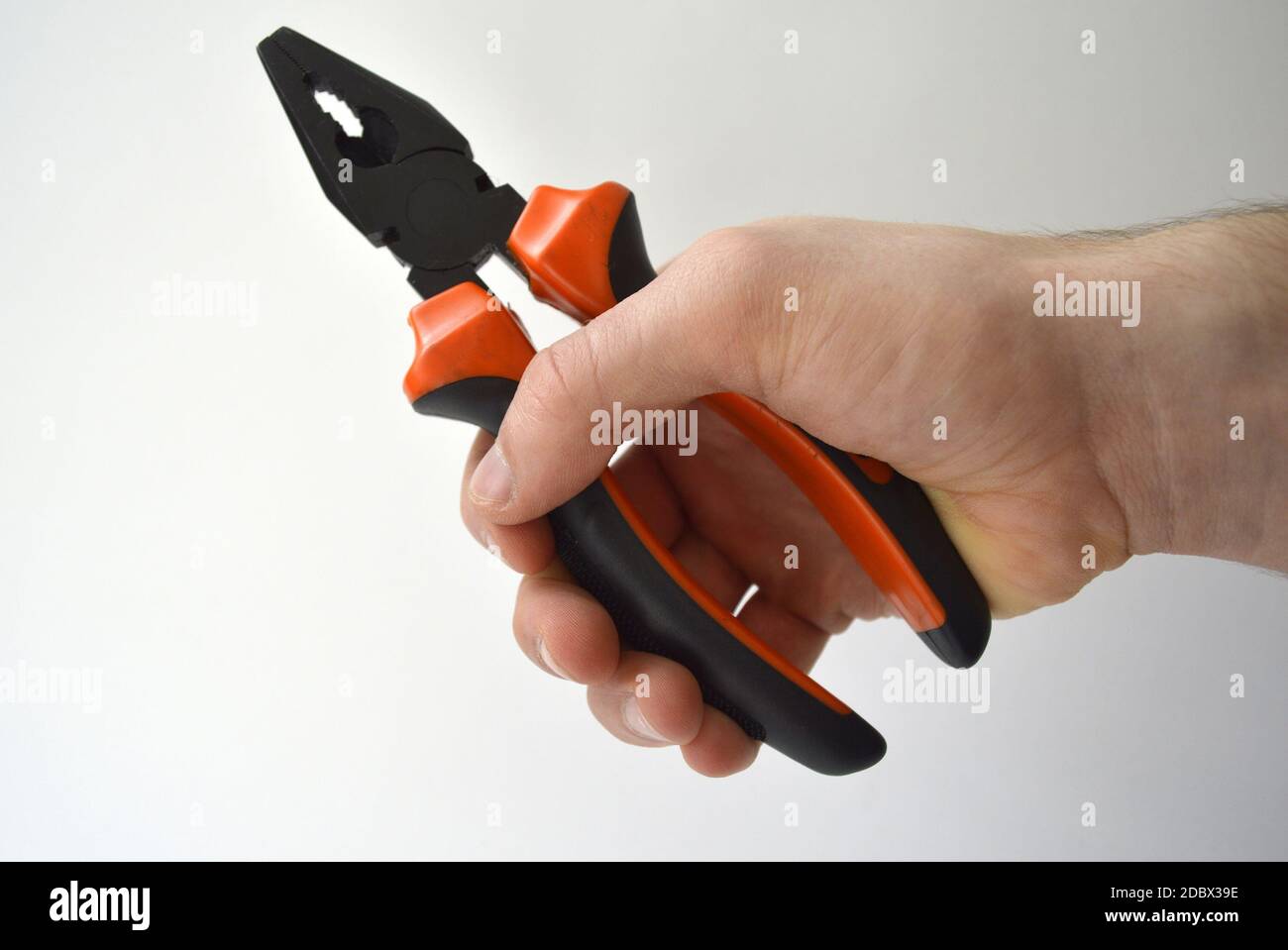 Man's hand holding pliers isolated on white background Stock Photo - Alamy