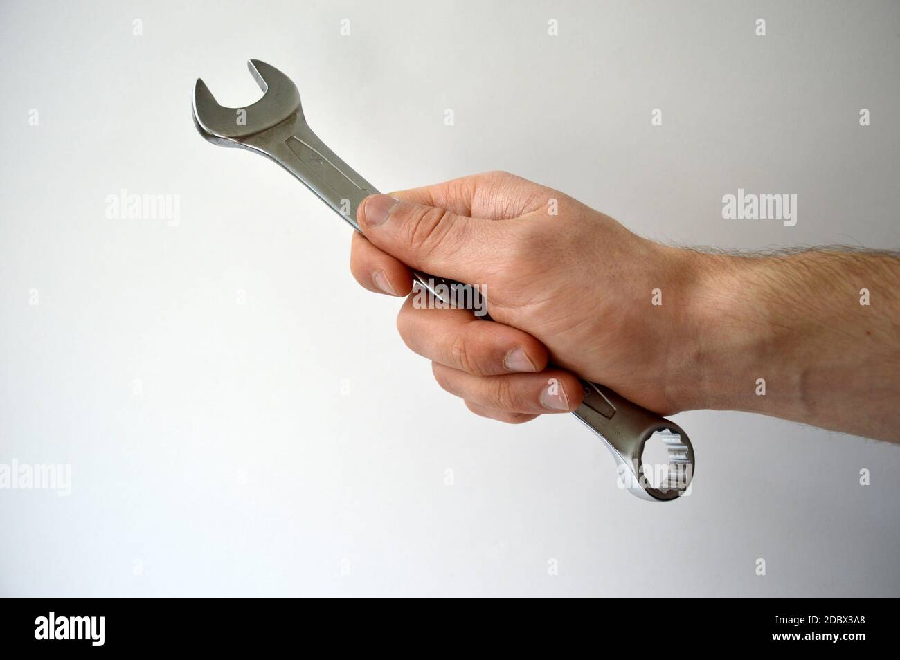 Man's hand holding wrench isolated on white background Stock Photo - Alamy