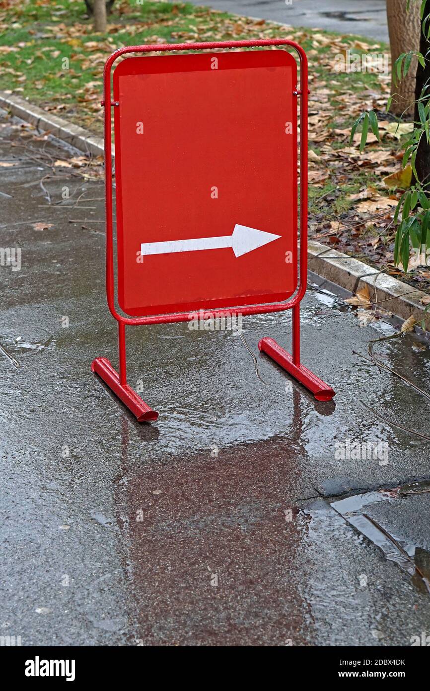 Red direction board at sidewalk Stock Photo - Alamy