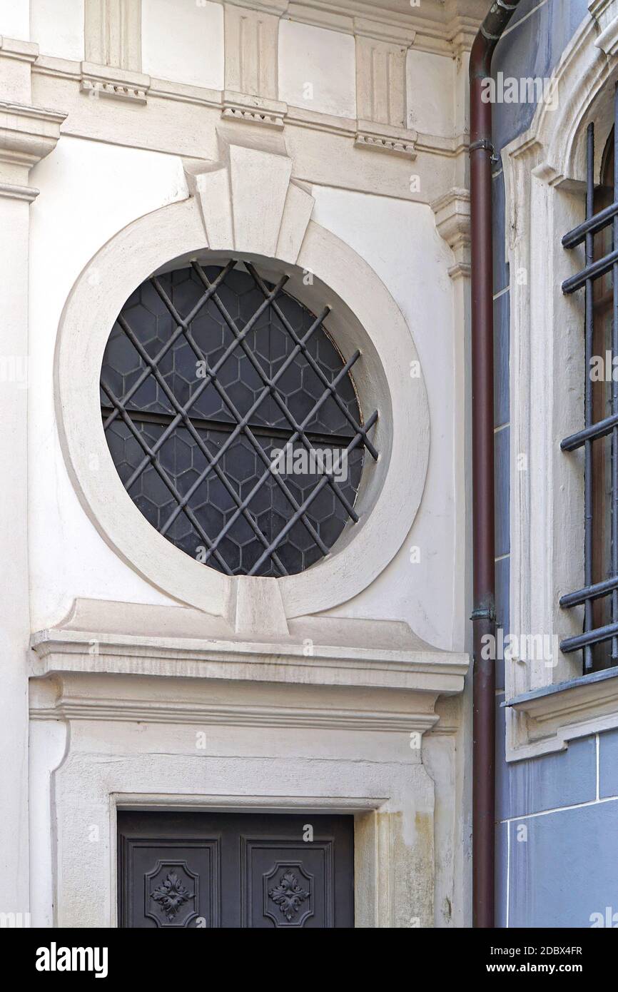 Round window with bars above door Stock Photo - Alamy