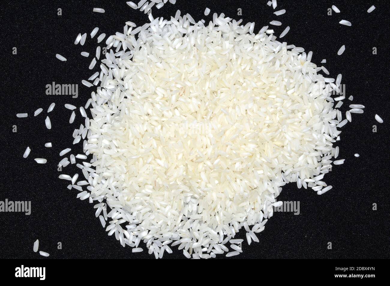 Heap of white rice on black background Stock Photo - Alamy
