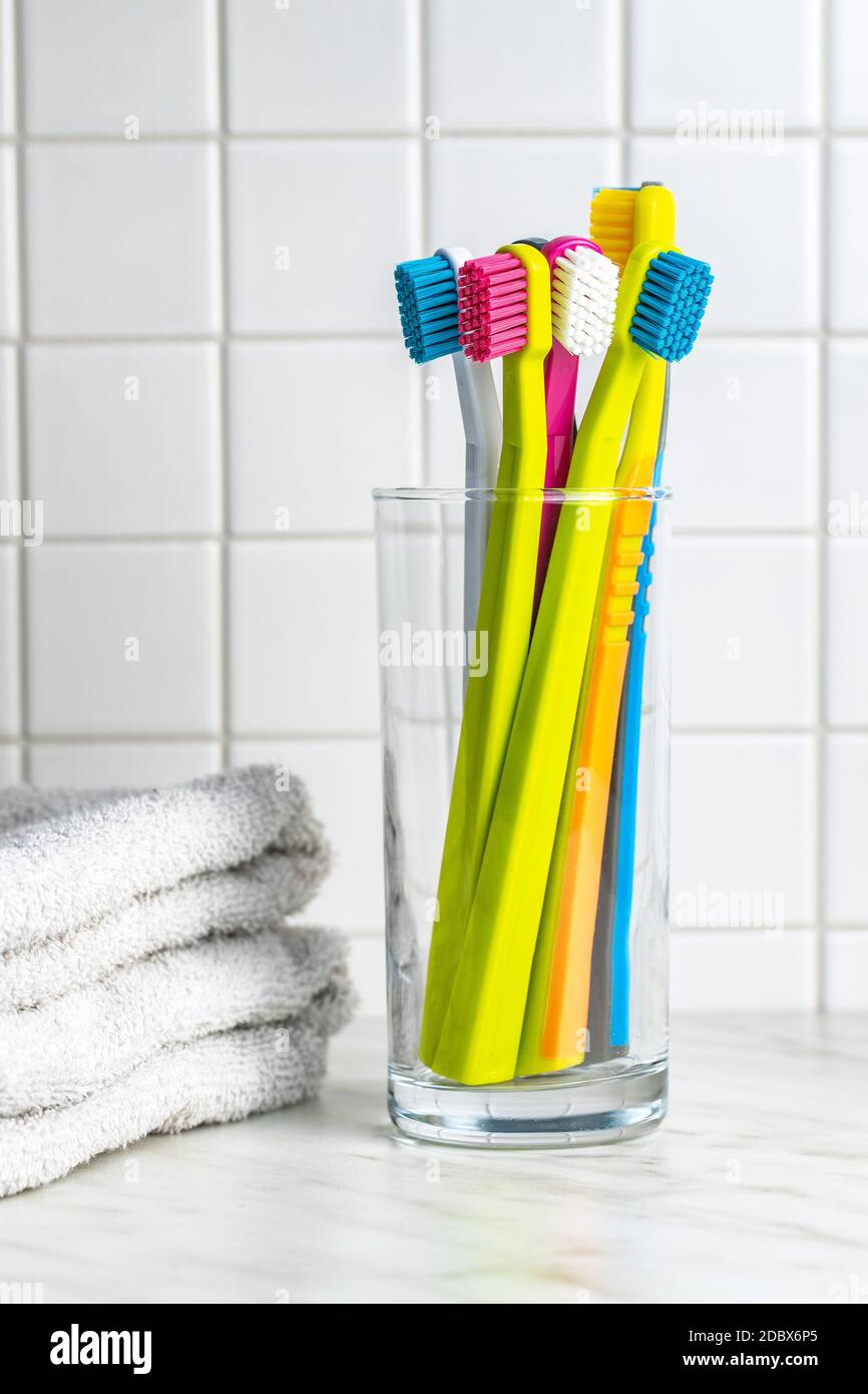 Various colorful toothbrushes in cup Stock Photo - Alamy