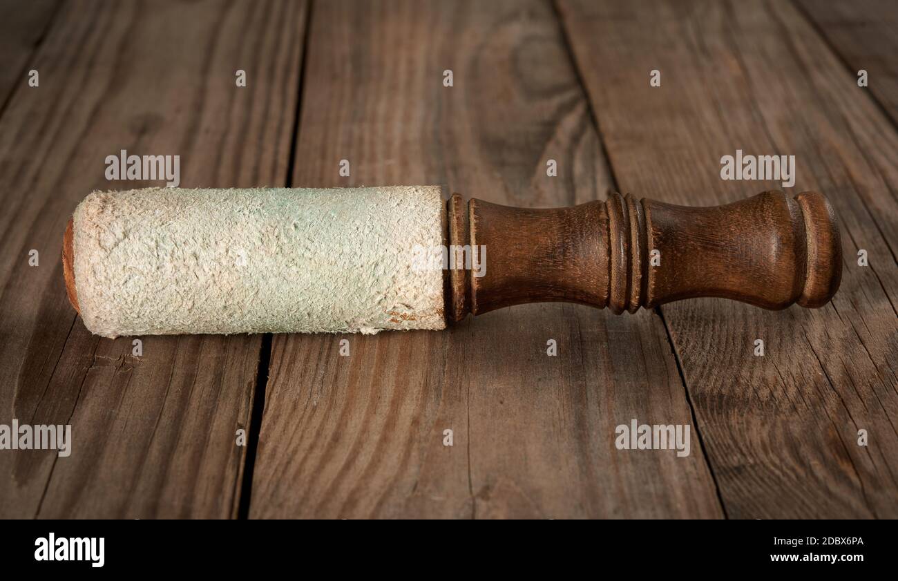 old wooden clapper for singing bowls on a gray wooden background, close ...