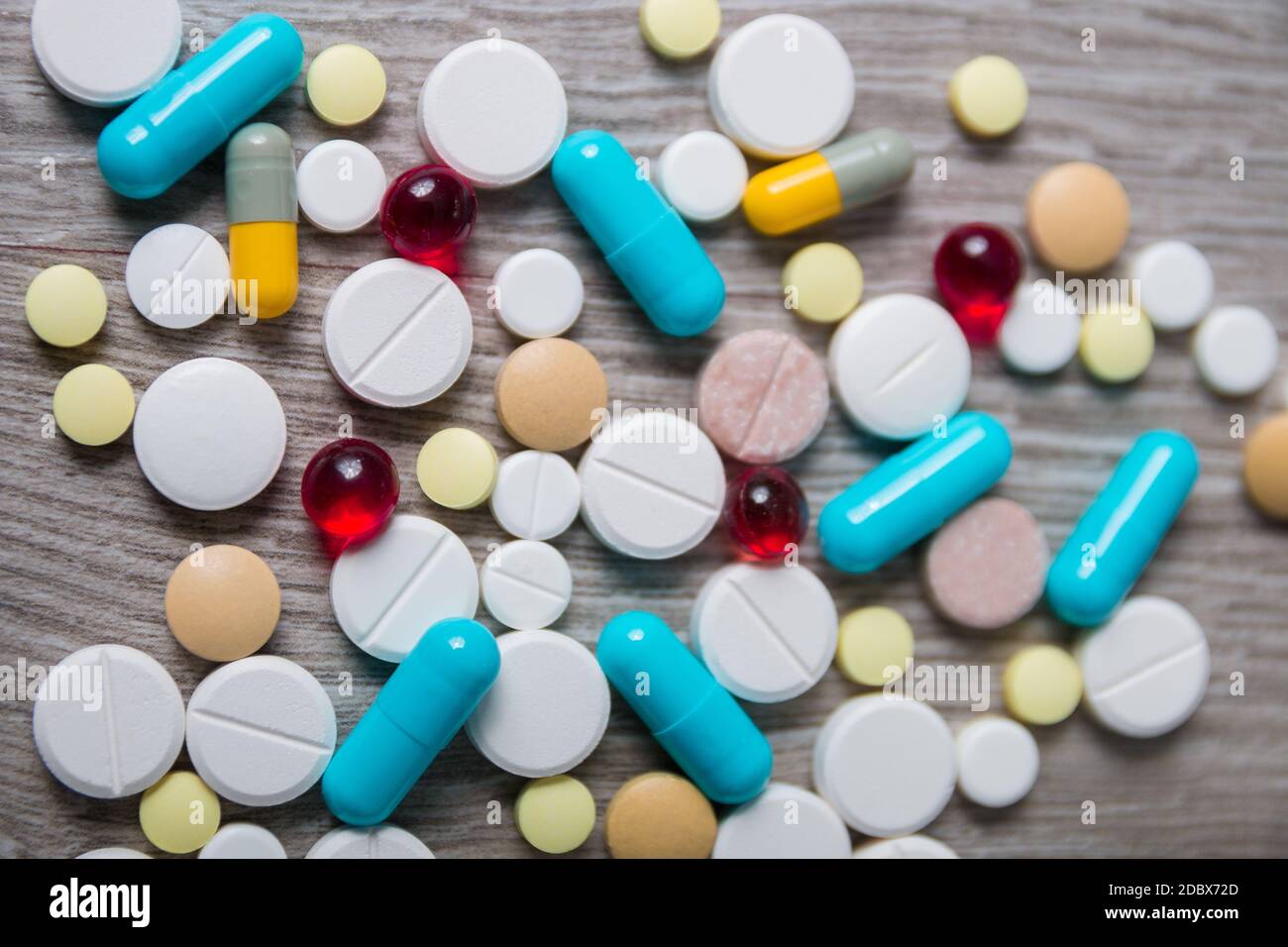 A lot of colorful medication and pills from above on grey wooden ...