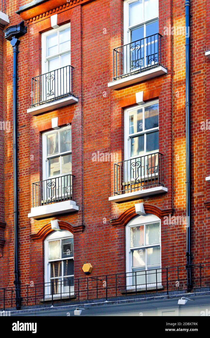 Sunlight in windows at red brick building Stock Photo - Alamy