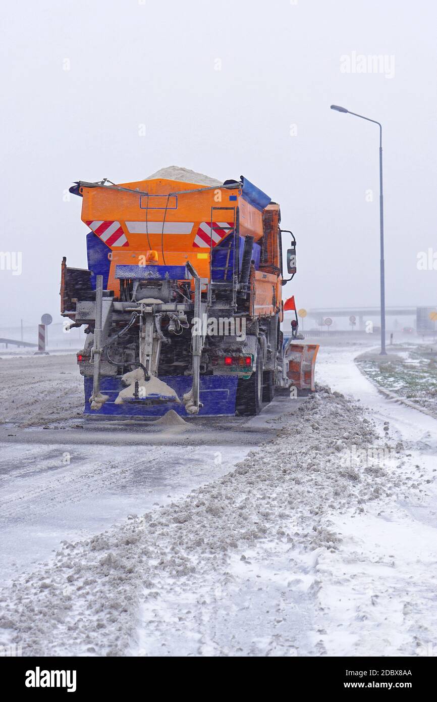 Snowplow truck with salt spreader at highway Stock Photo - Alamy