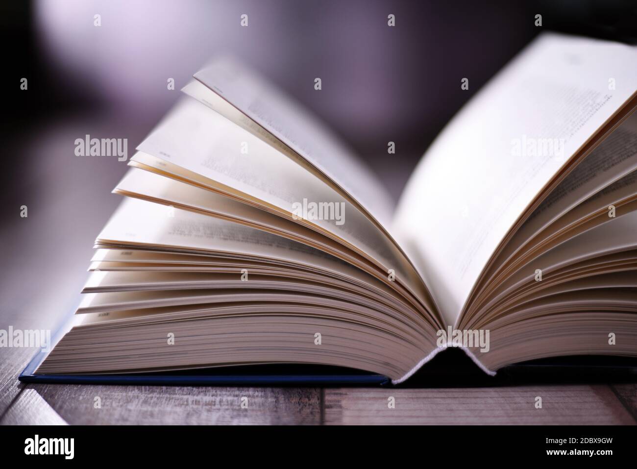 Composition with open book on the table Stock Photo - Alamy