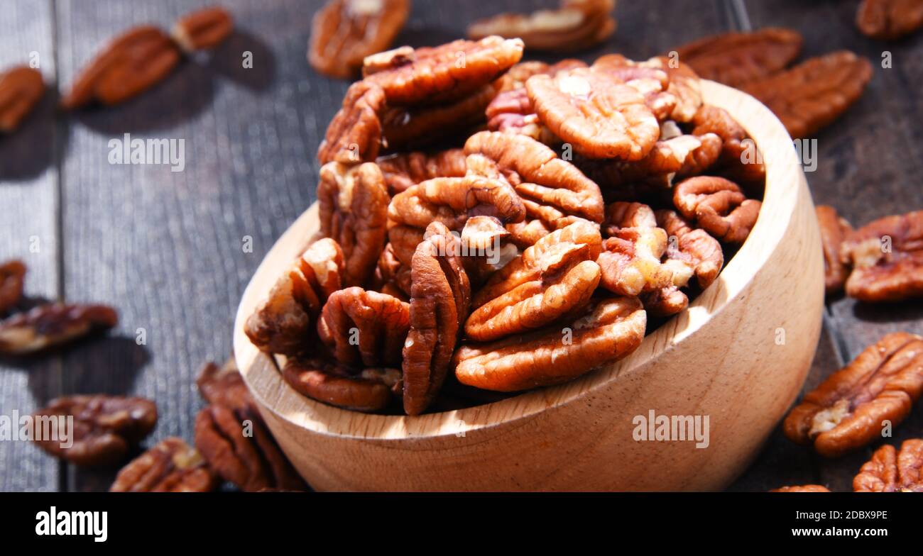 Bowl with pecan nuts on wooden table. Delicacies Stock Photo - Alamy