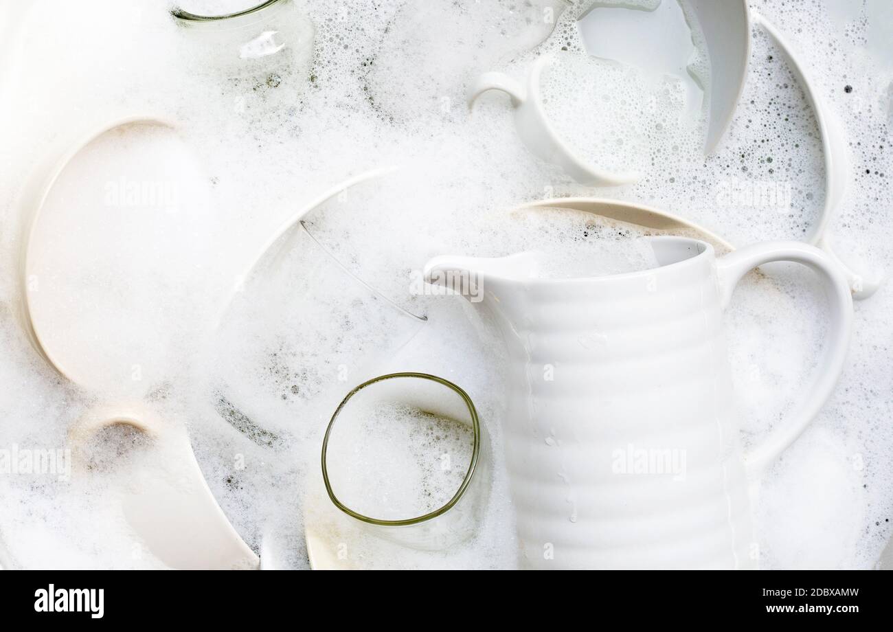 Washing dishes, Close up of utensils soaking in kitchen sink. Top view ...