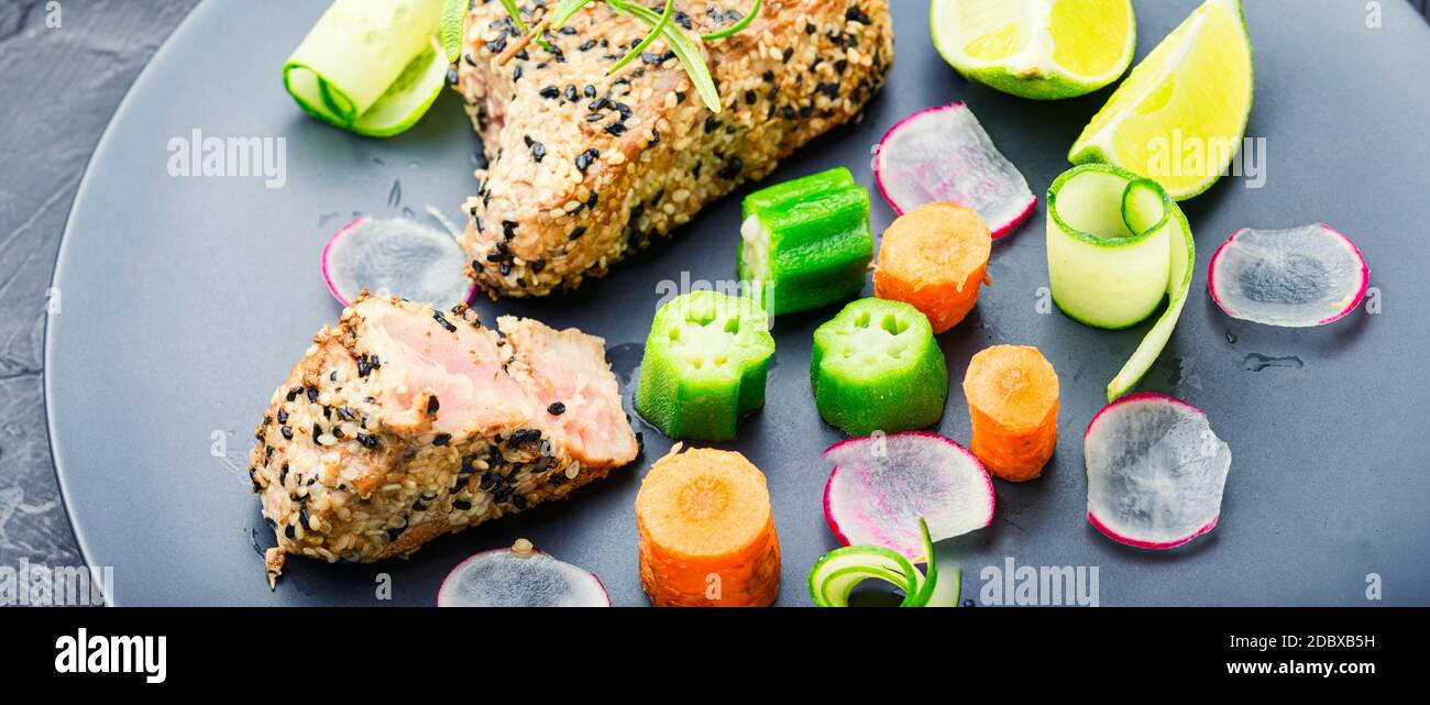 Baked tuna steak with vegetable garnish.Fish cooked with vegetables ...