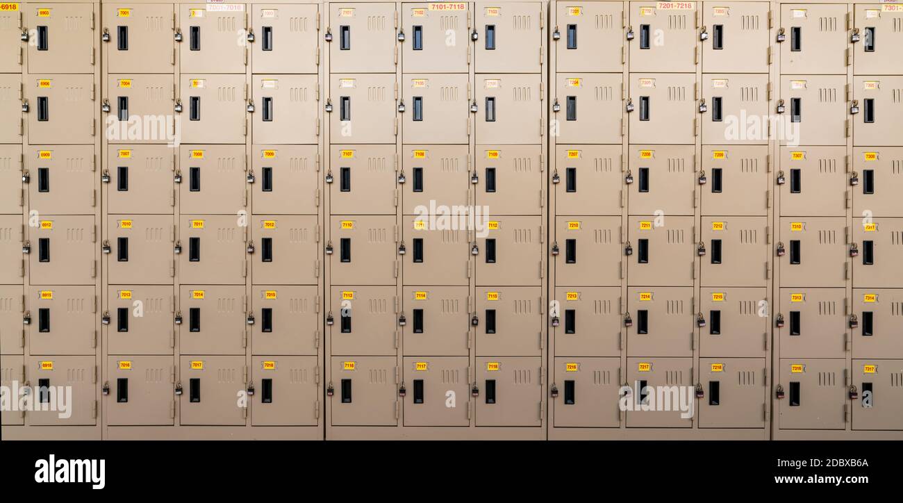Closeup beige locker with lock and numbered yellow tags at locker room ...