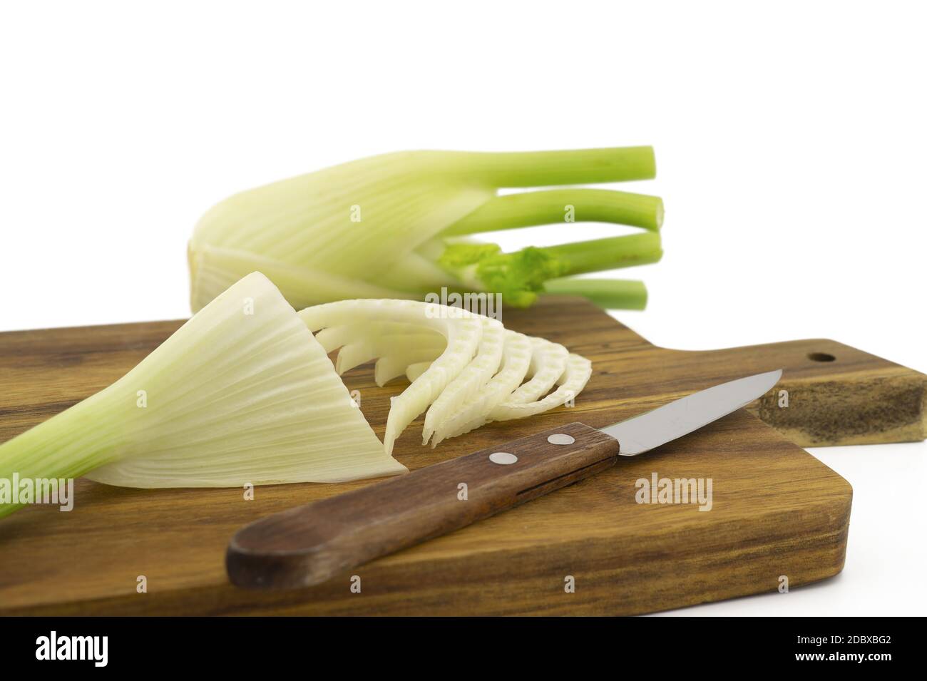 Preparing fresh fennel slicing them on a wooden cutting board over a ...
