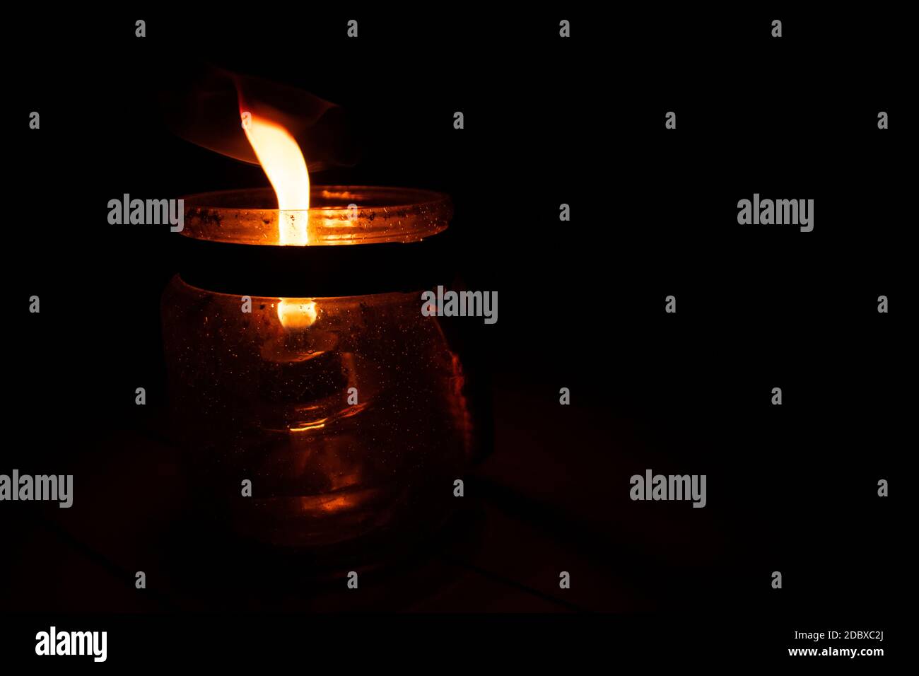 A Lit Candle Inside a Mason Jar on a Pure Darkness Stock Photo - Alamy