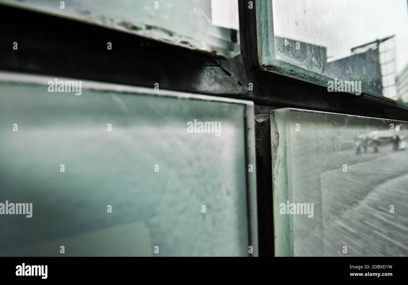 Abstract detail of dirty glass panes on side of the building reflecting ...