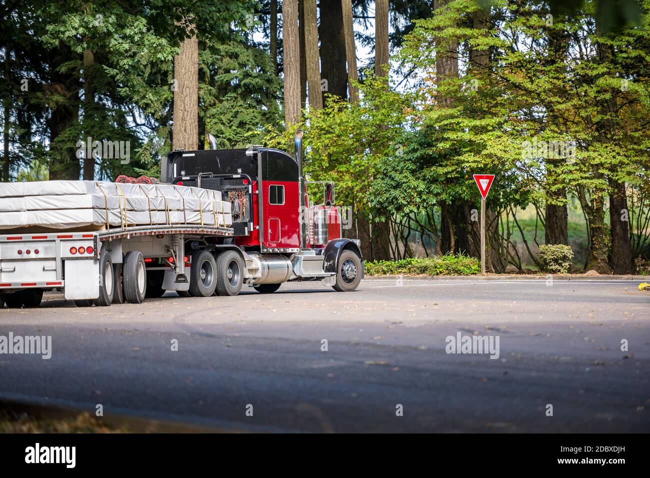 Classic dark red long hauler big rig industrial semi truck tractor with ...