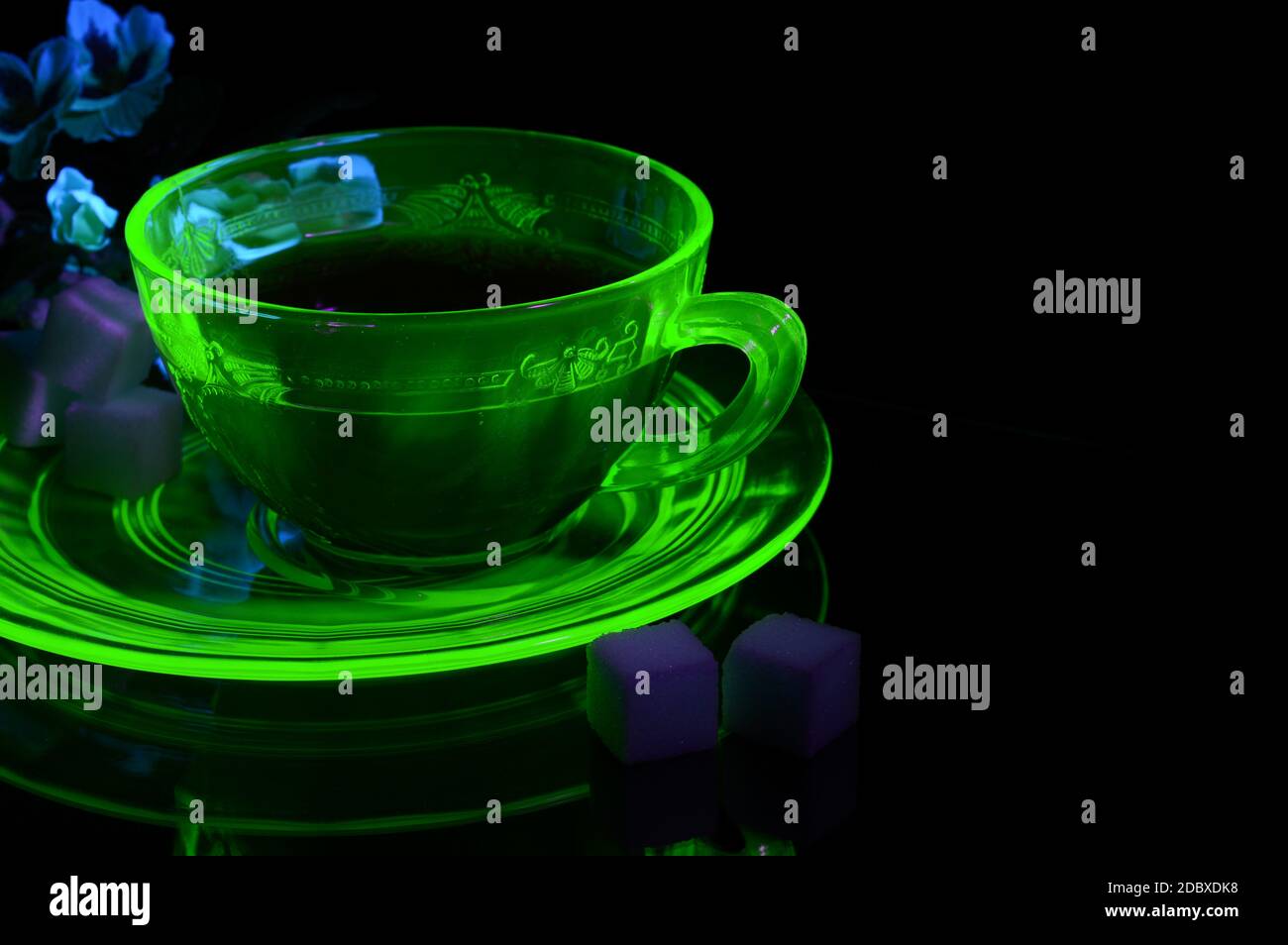 A glowing Uranium Glass Teacup and Saucer under some ultraviolet light ...