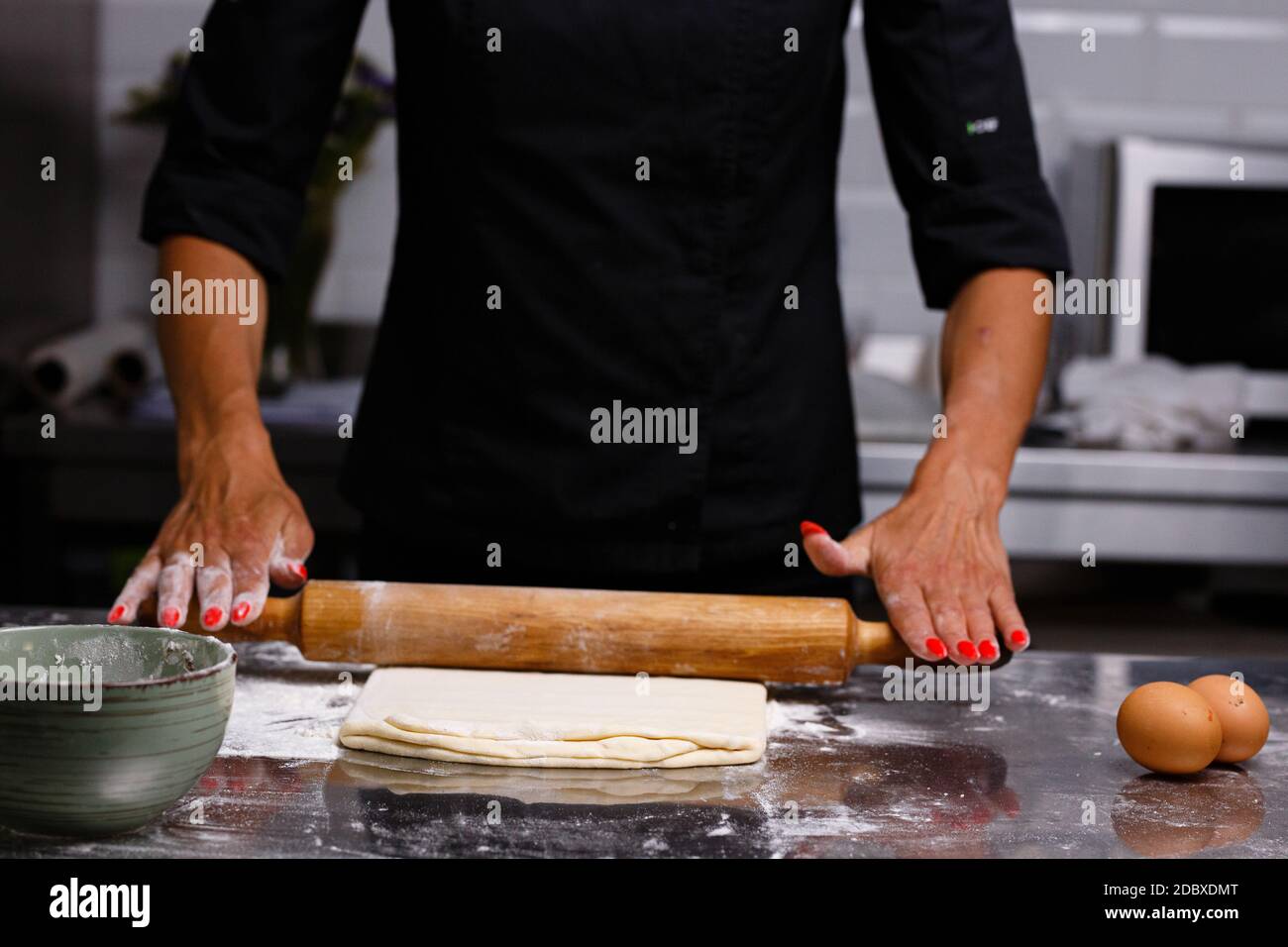 The chef prepares pastries in a professional kitchen. Knead the dough ...