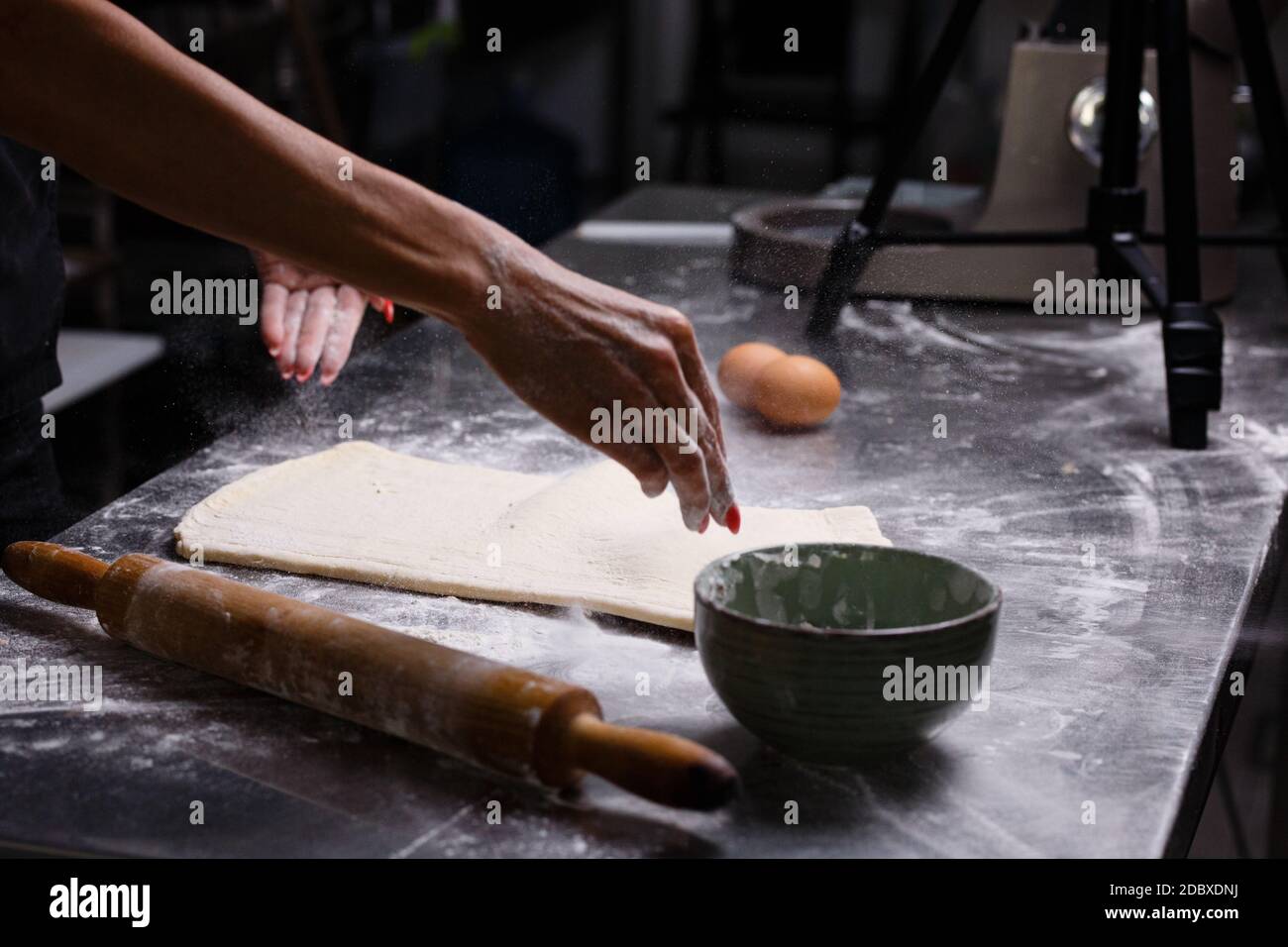 The chef prepares pastries in a professional kitchen. Knead the dough ...