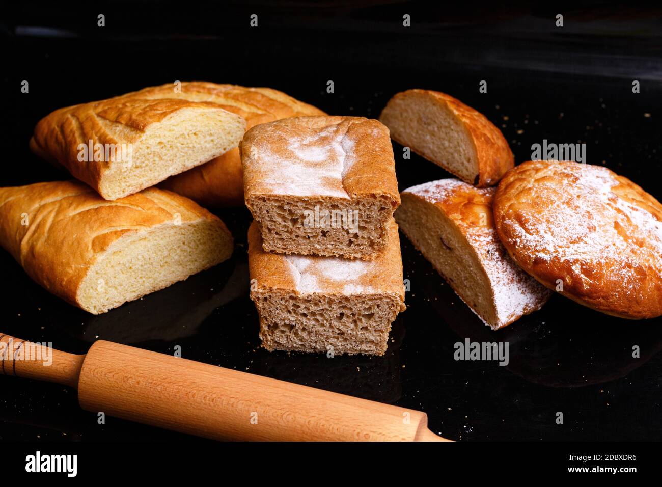 Baking on a black background with a rolling pin. Lots of pastries and ...