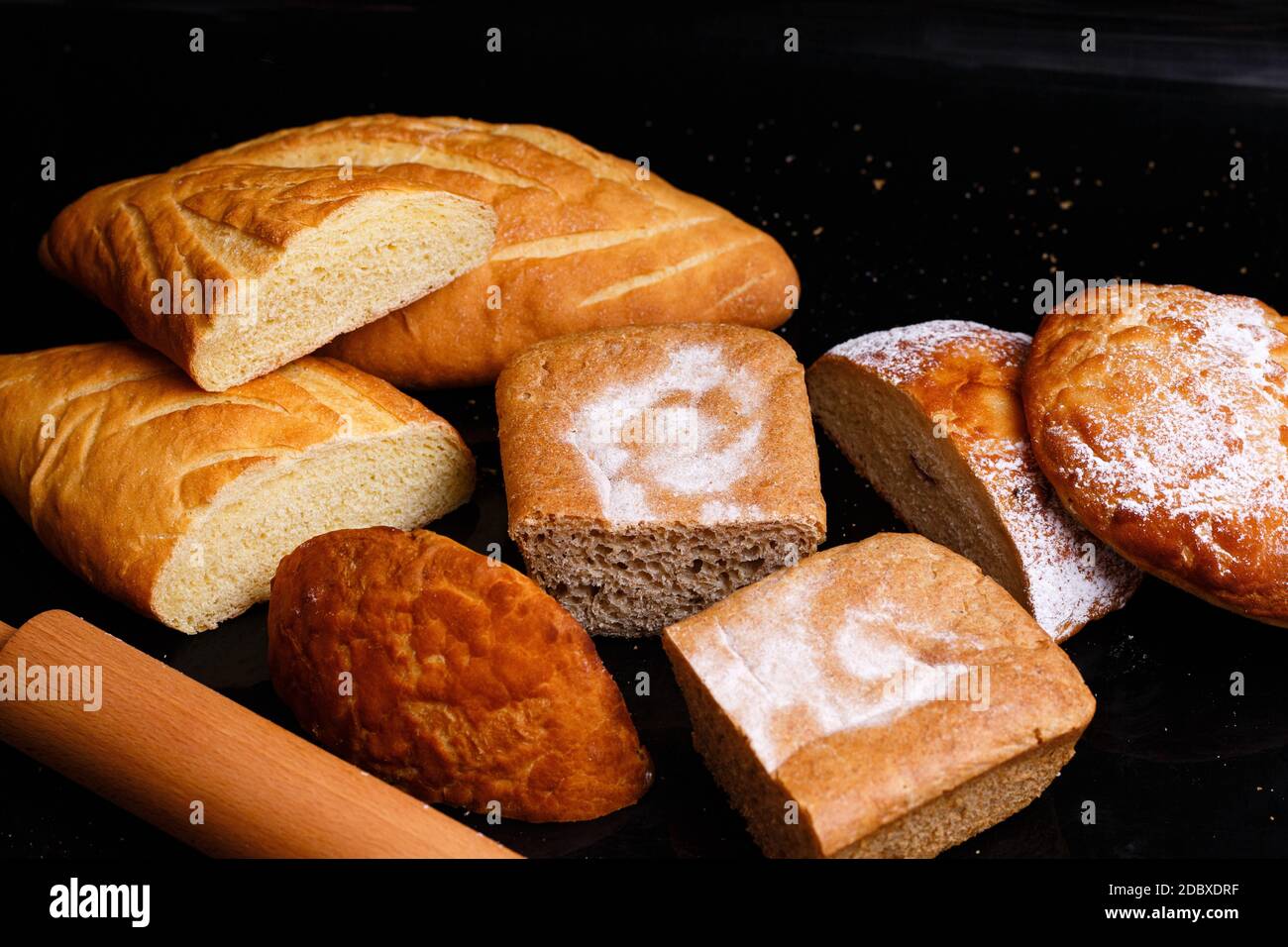 Baking on a black background with a rolling pin. Lots of pastries and ...