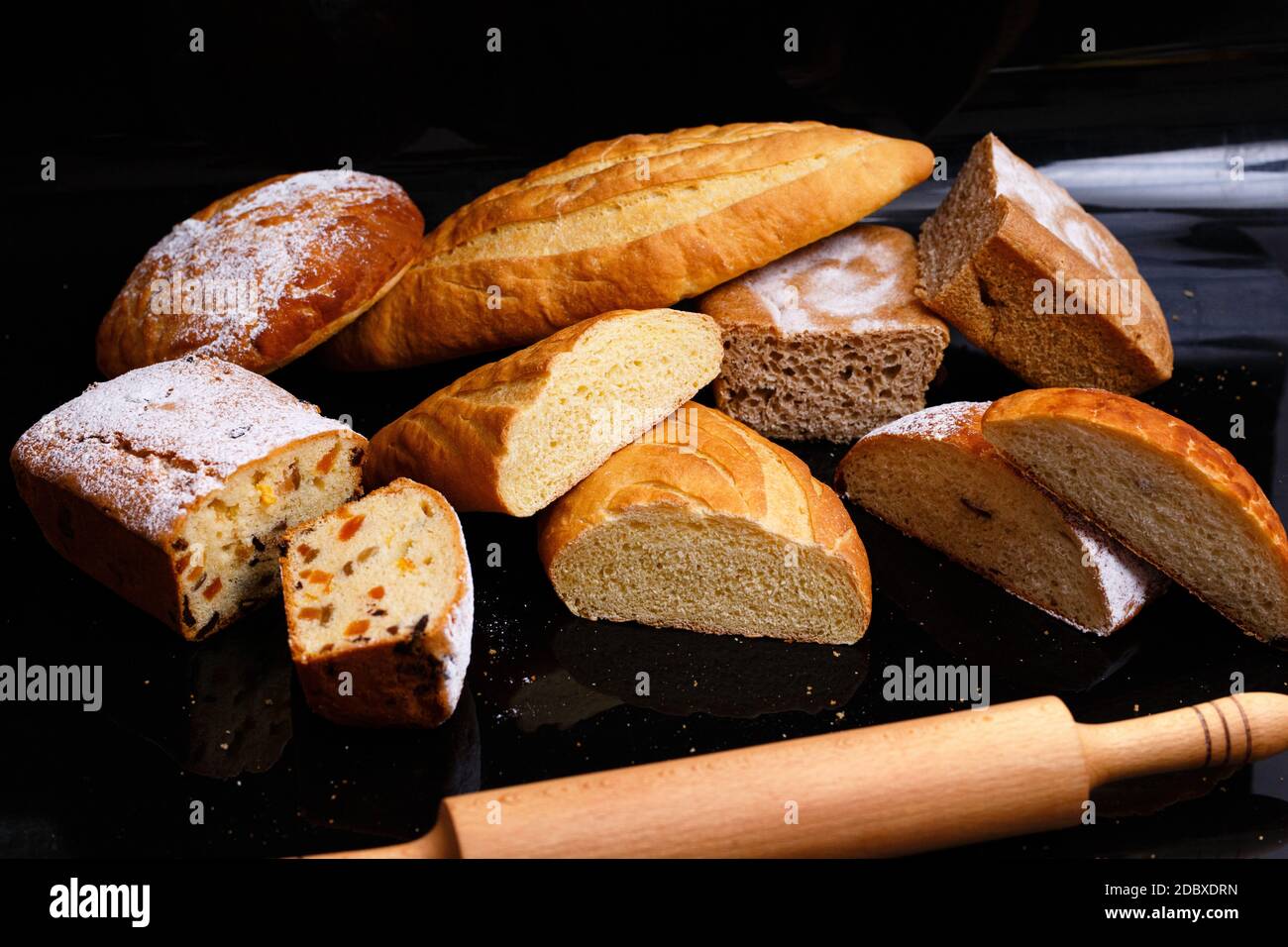 Baking on a black background with a rolling pin. Lots of pastries and ...