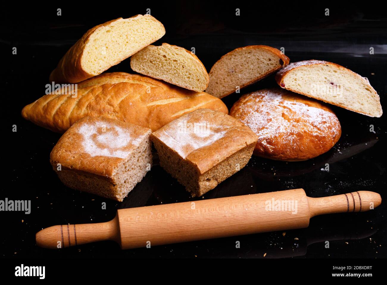 Baking on a black background with a rolling pin. Lots of pastries and ...