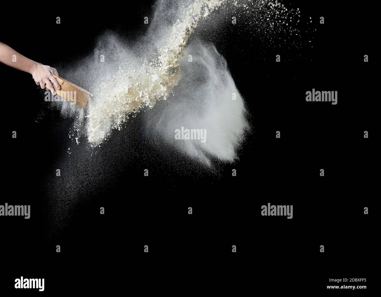 female hand sifts white wheat flour through a round wooden sieve on a ...