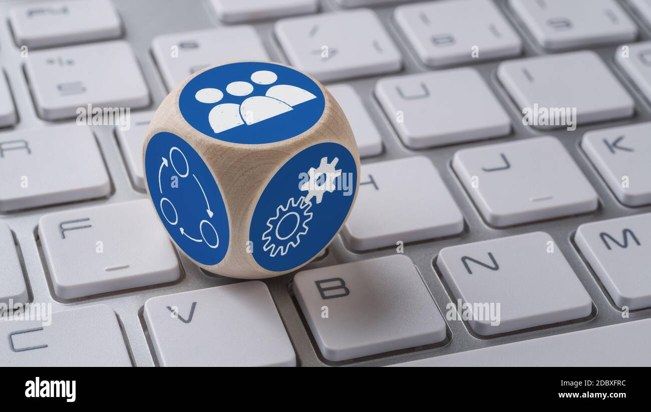 A die with icons on a keyboard - Teamwork Stock Photo - Alamy