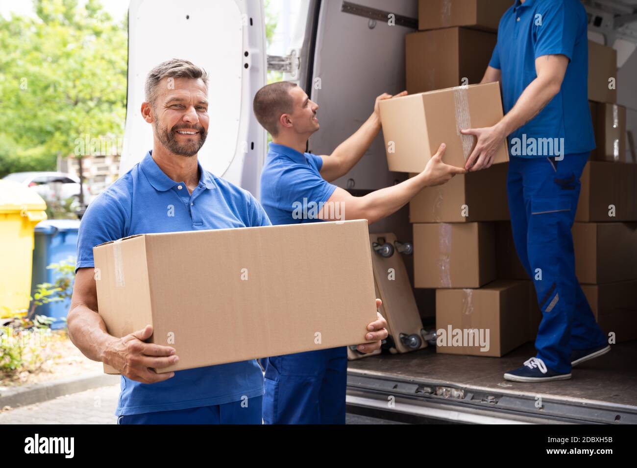 Truck Movers Loading Van Carrying Boxes And Moving House Stock Photo ...