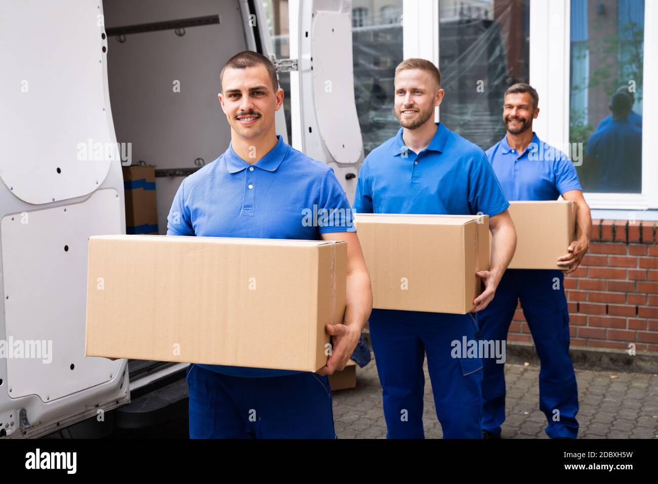 Truck Movers Loading Van Carrying Boxes And Moving House Stock Photo ...