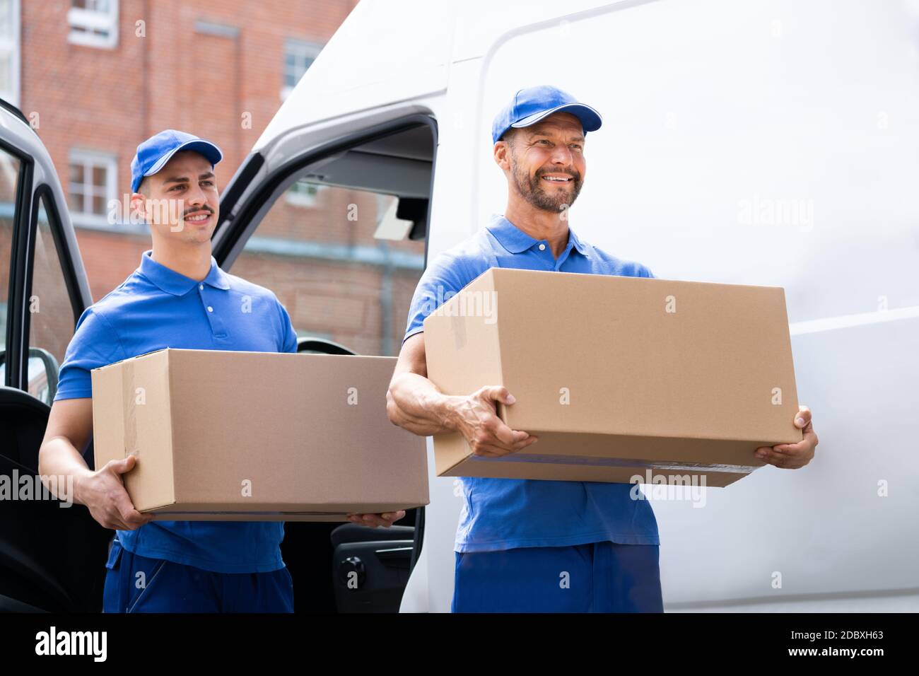 Delivery man carrying boxes on a hand truck hi-res stock photography ...